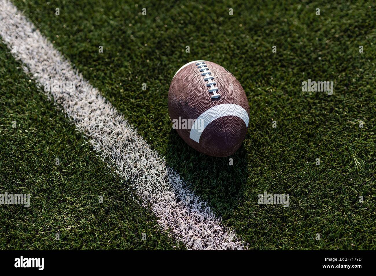 American rugby ball on the grass in the stadium Stock Photo - Alamy