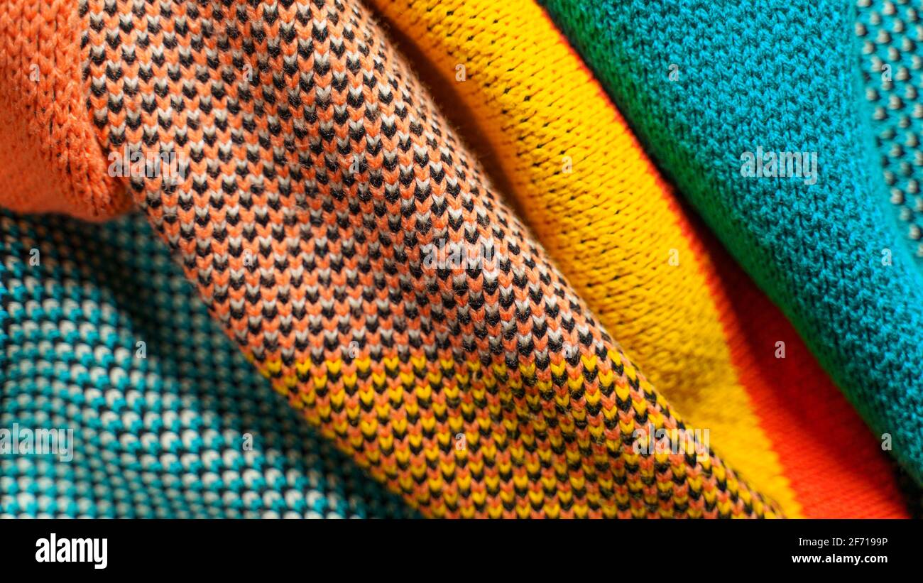 A stack of colorful knitted fabrics of different structures and ...