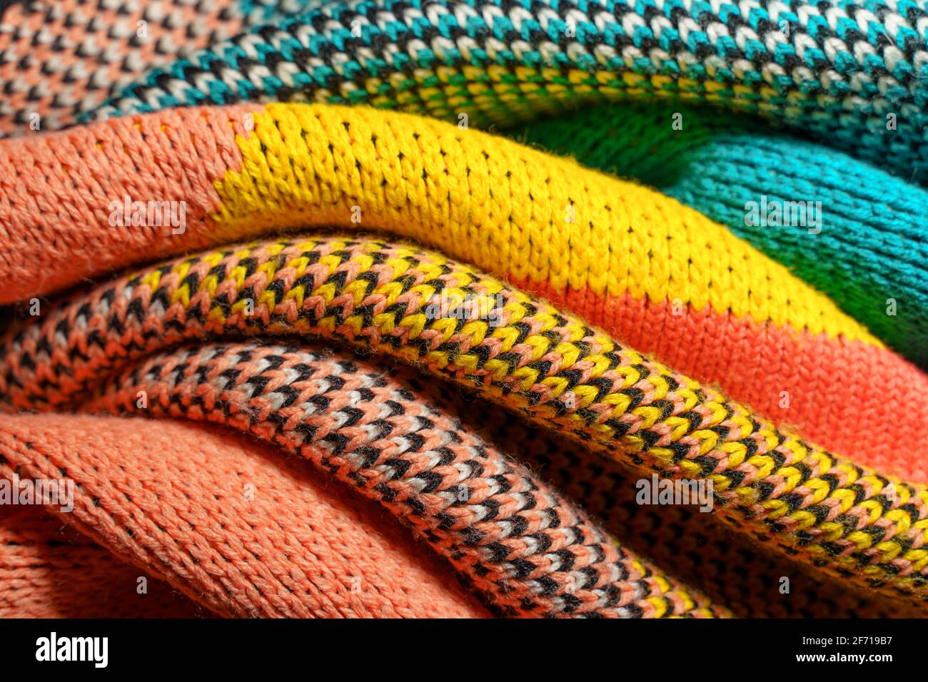 A stack of colorful knitted fabrics of different structures and ...