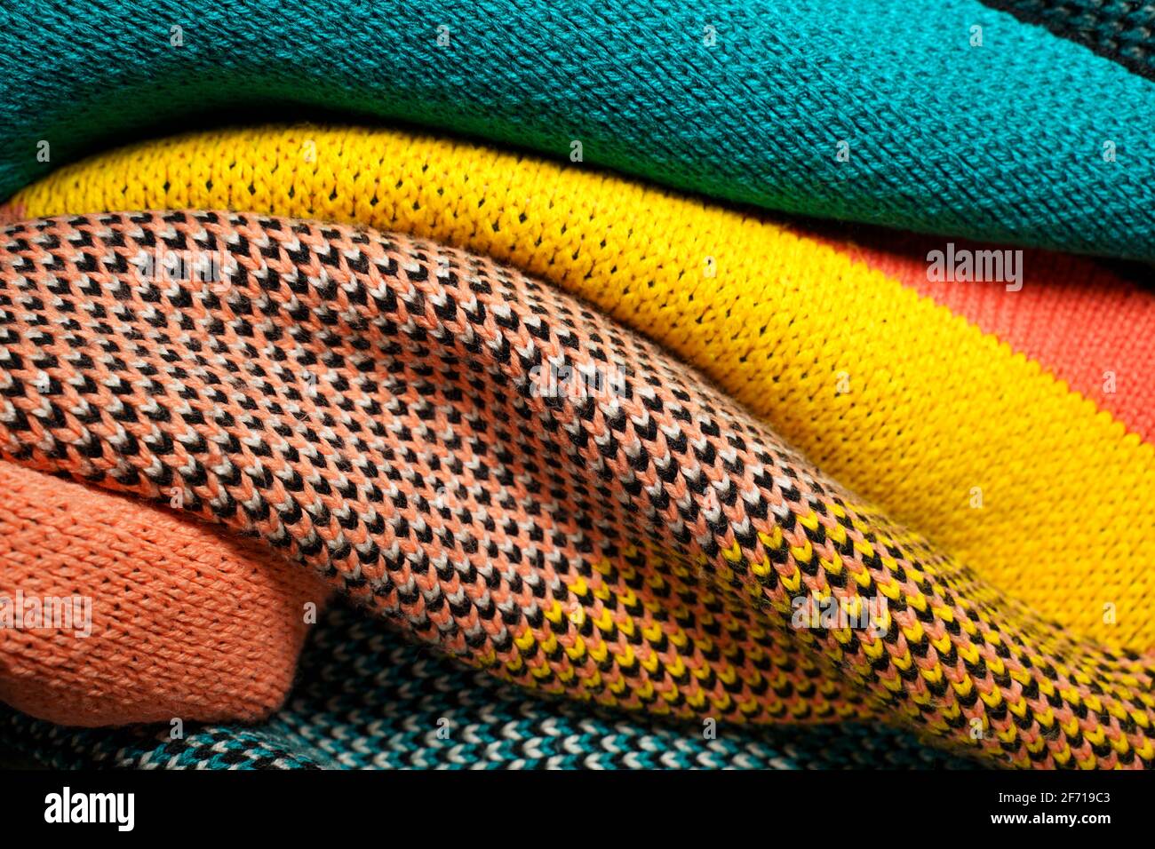 A stack of colorful knitted fabrics of different structures and ...