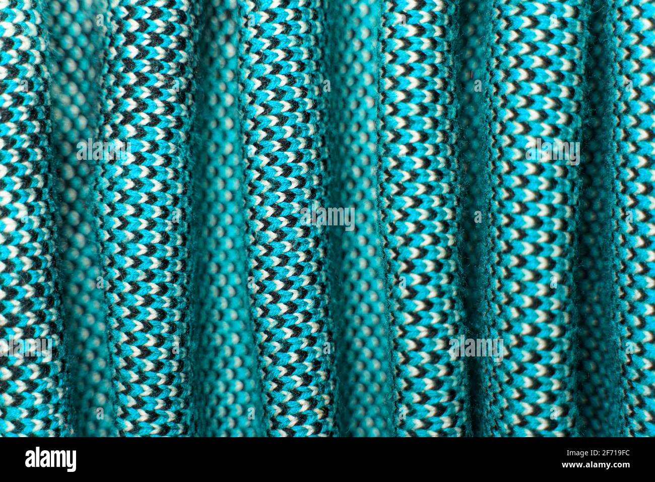 Folded synthetic knitted fabric with pattern elements of blue, black ...