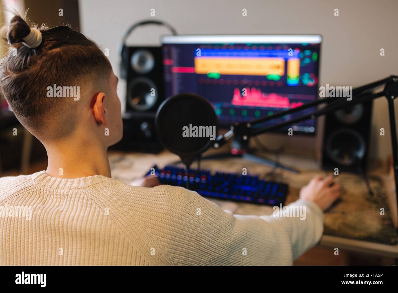 Young happy dj man wearing headphones and working at home while making ...