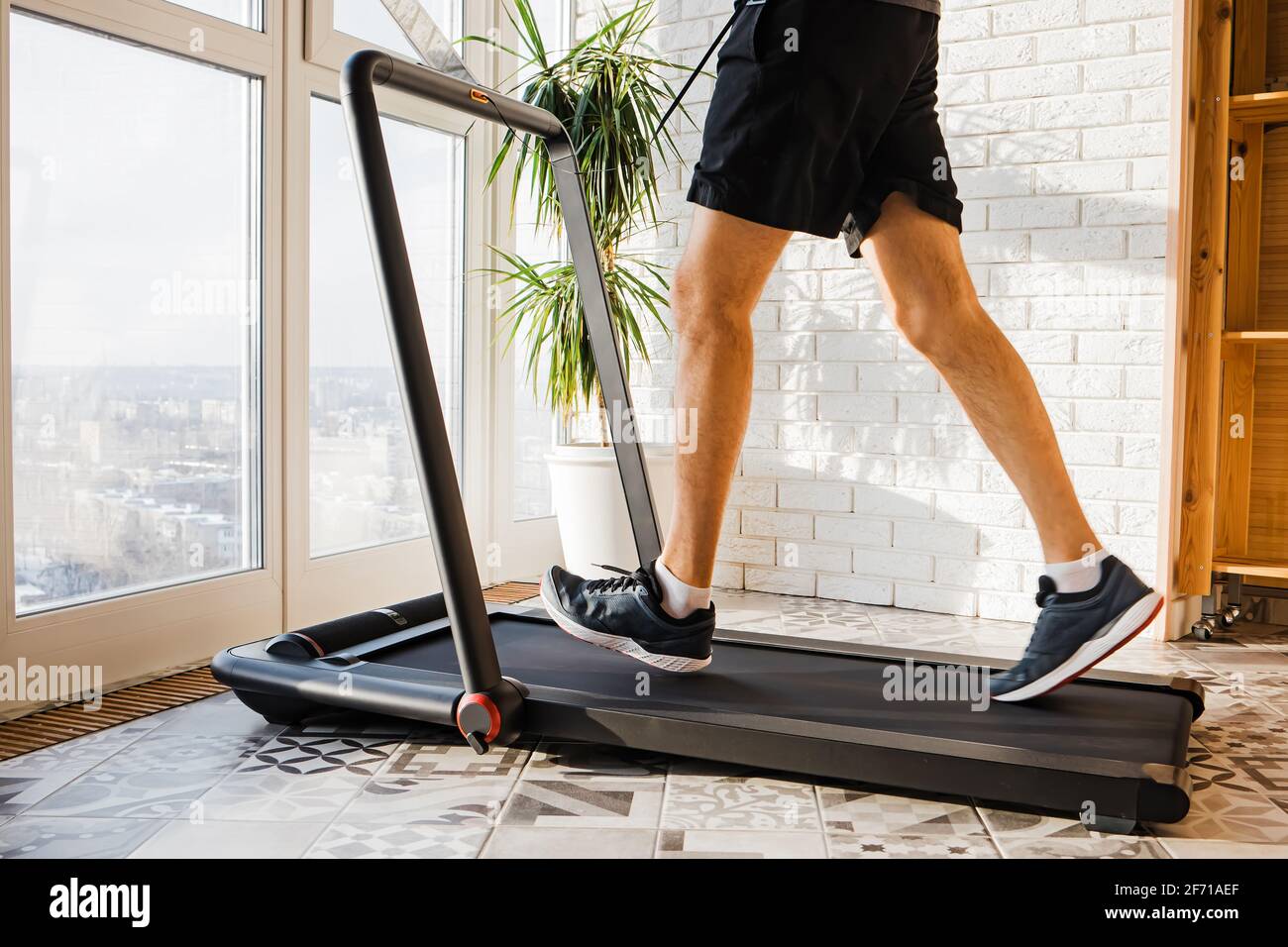 Man jogging on the modern compact treadmill at his home Stock Photo - Alamy