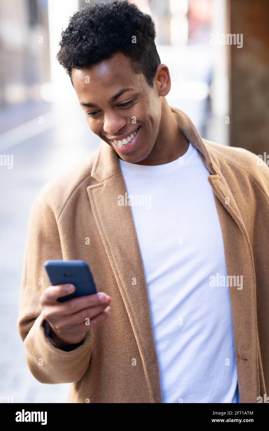 Young black man using his smartphone outdoors Stock Photo - Alamy