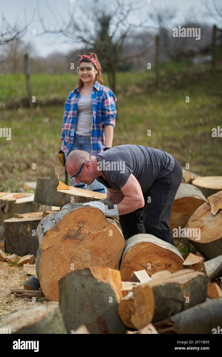 Couple splitting large beech wood in the backyard Stock Photo - Alamy