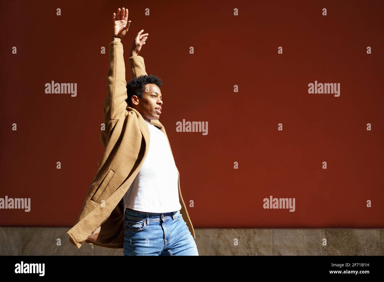 Young Cuban man dancing on red urban wall Stock Photo - Alamy