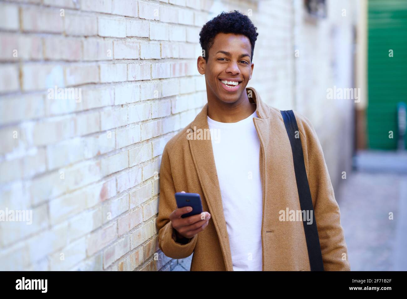 Young black man using his smartphone outdoors Stock Photo - Alamy