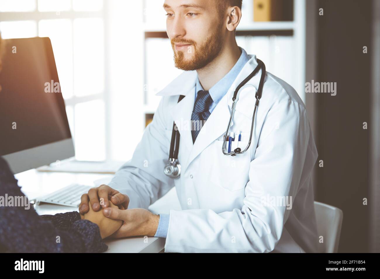 Friendly red-beard doctor reassuring his female patient. Medical ethics ...