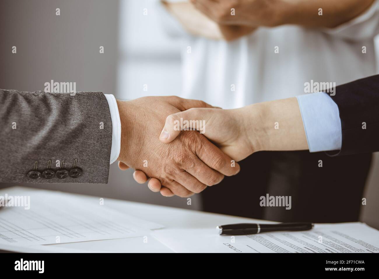 Business people shaking hands finishing contract signing, close-up ...