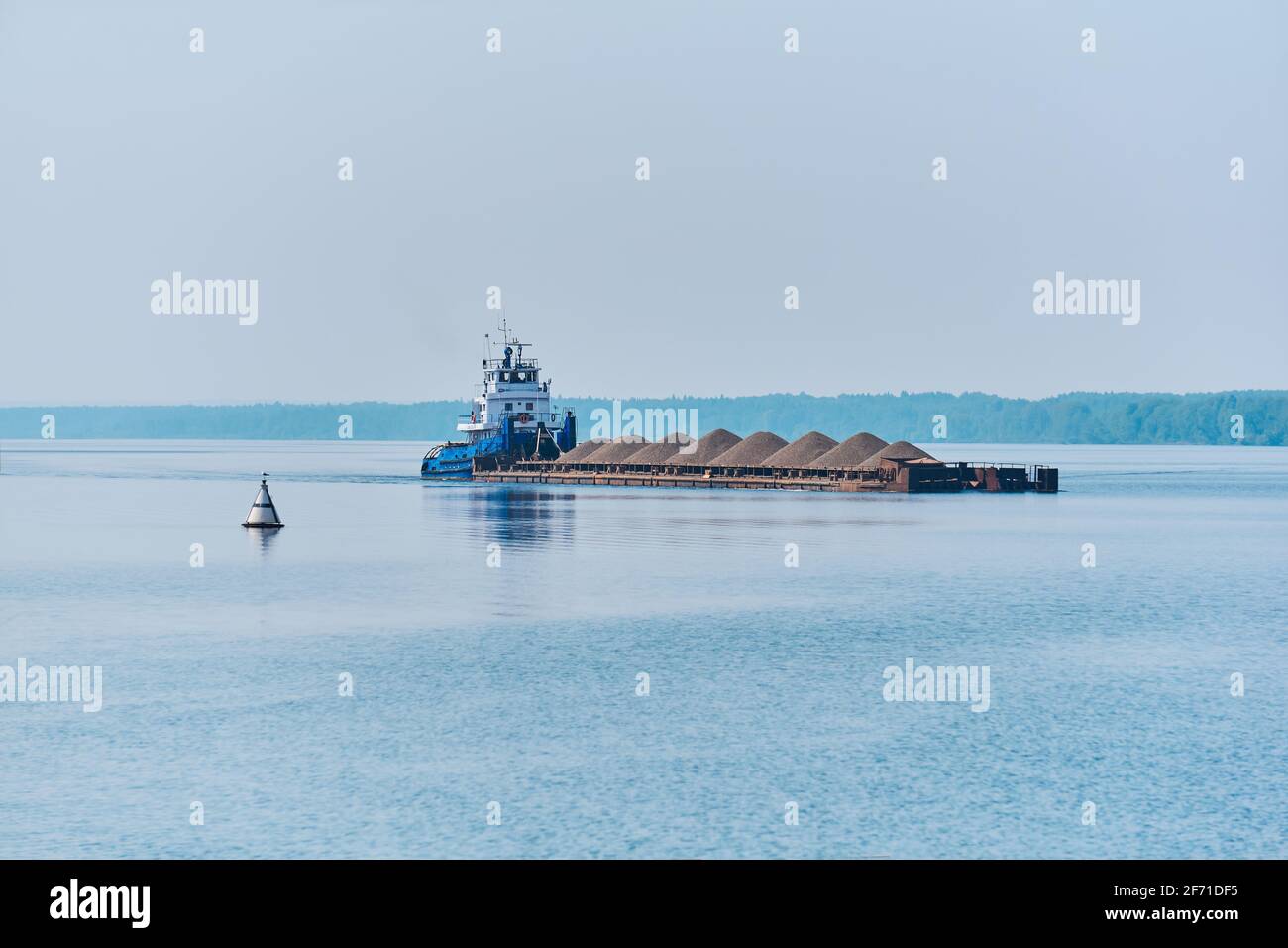 towboat pushes dry bulk cargo barge with sand on the river in the ...