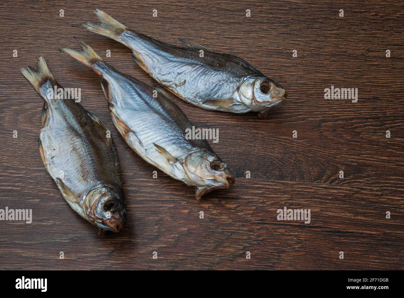 some dried fish on a dark wooden background Stock Photo - Alamy