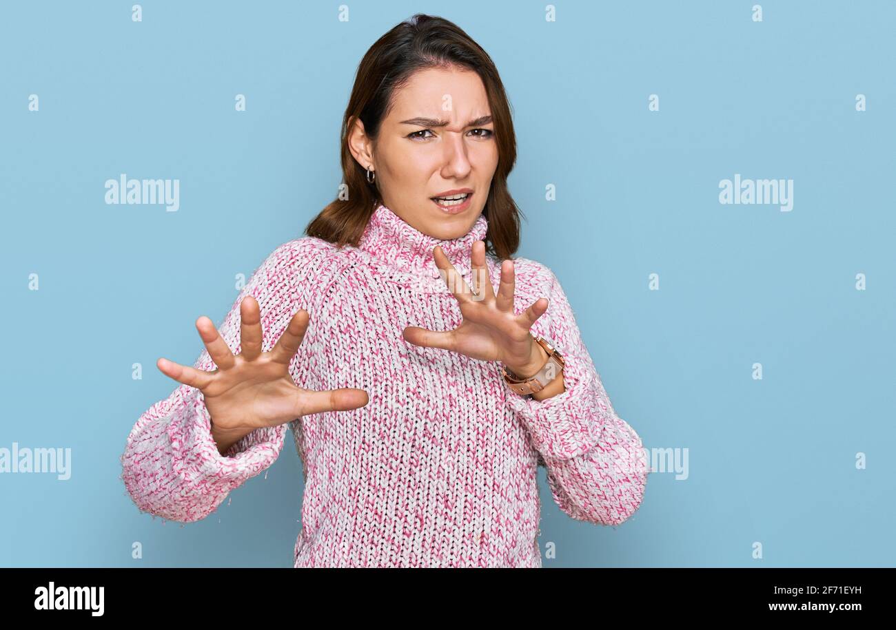 Young caucasian girl wearing wool winter sweater afraid and terrified ...