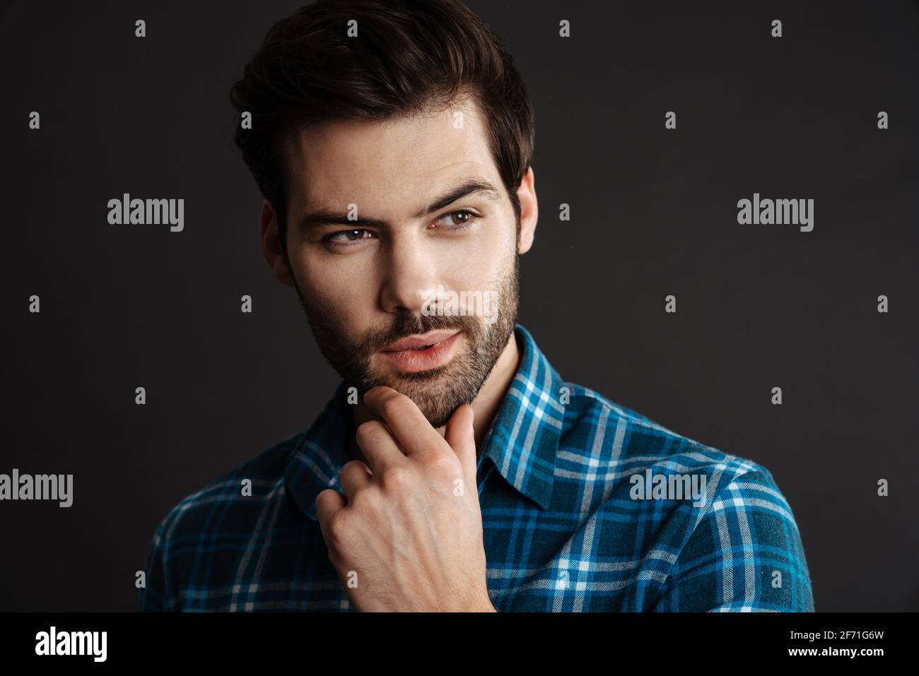 Pleased handsome unshaven guy posing and looking aside isolated over ...