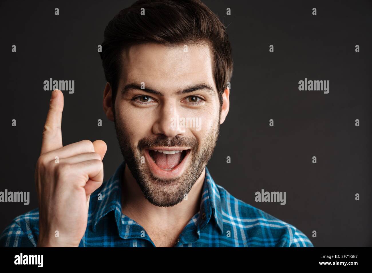 Excited handsome guy exclaiming and pointing finger upward isolated ...
