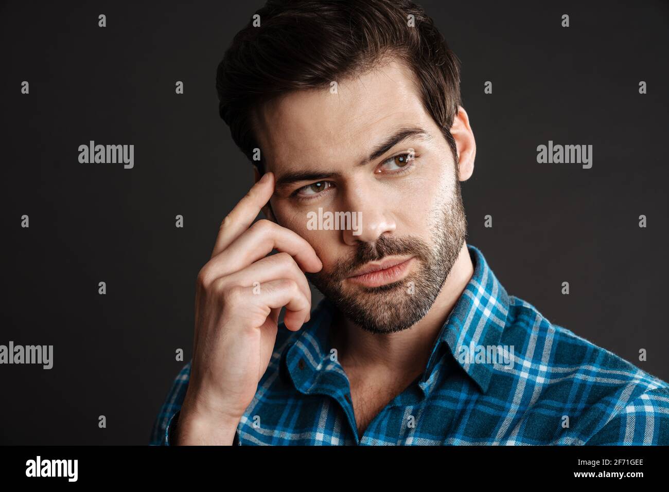 Thinking handsome unshaven guy posing and looking aside isolated over ...