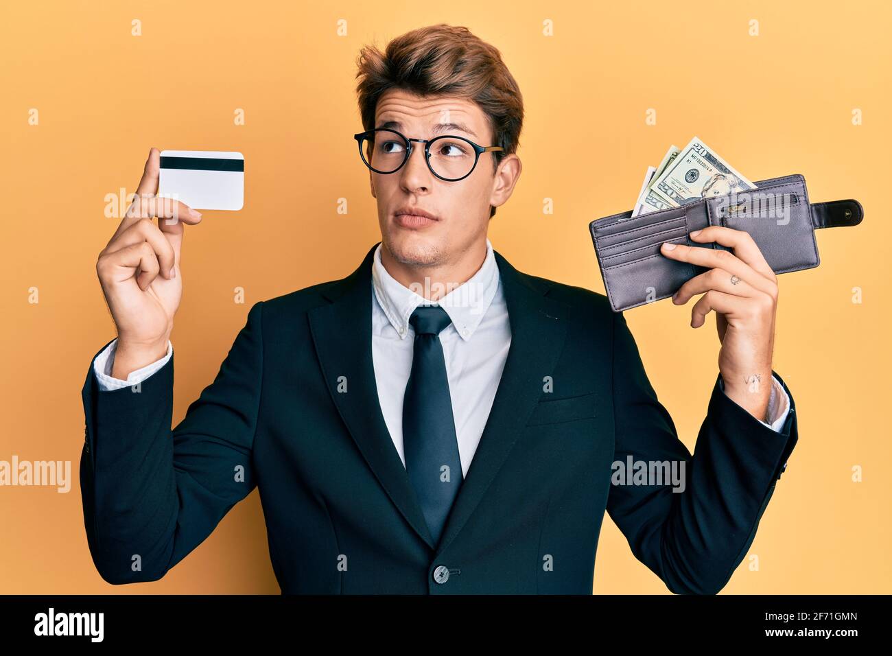 Handsome caucasian business man holding credit card and wallet with ...