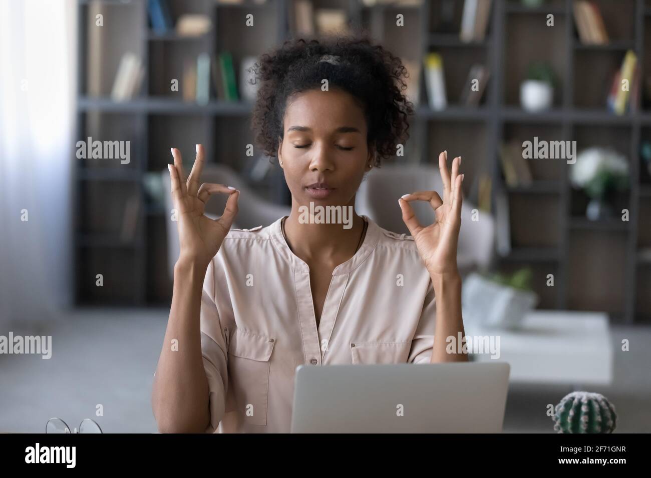 Calm African American woman meditate at workplace Stock Photo - Alamy
