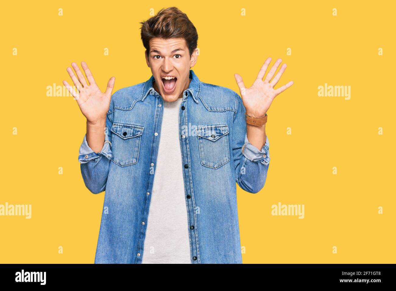 Handsome caucasian man wearing casual denim jacket celebrating crazy ...