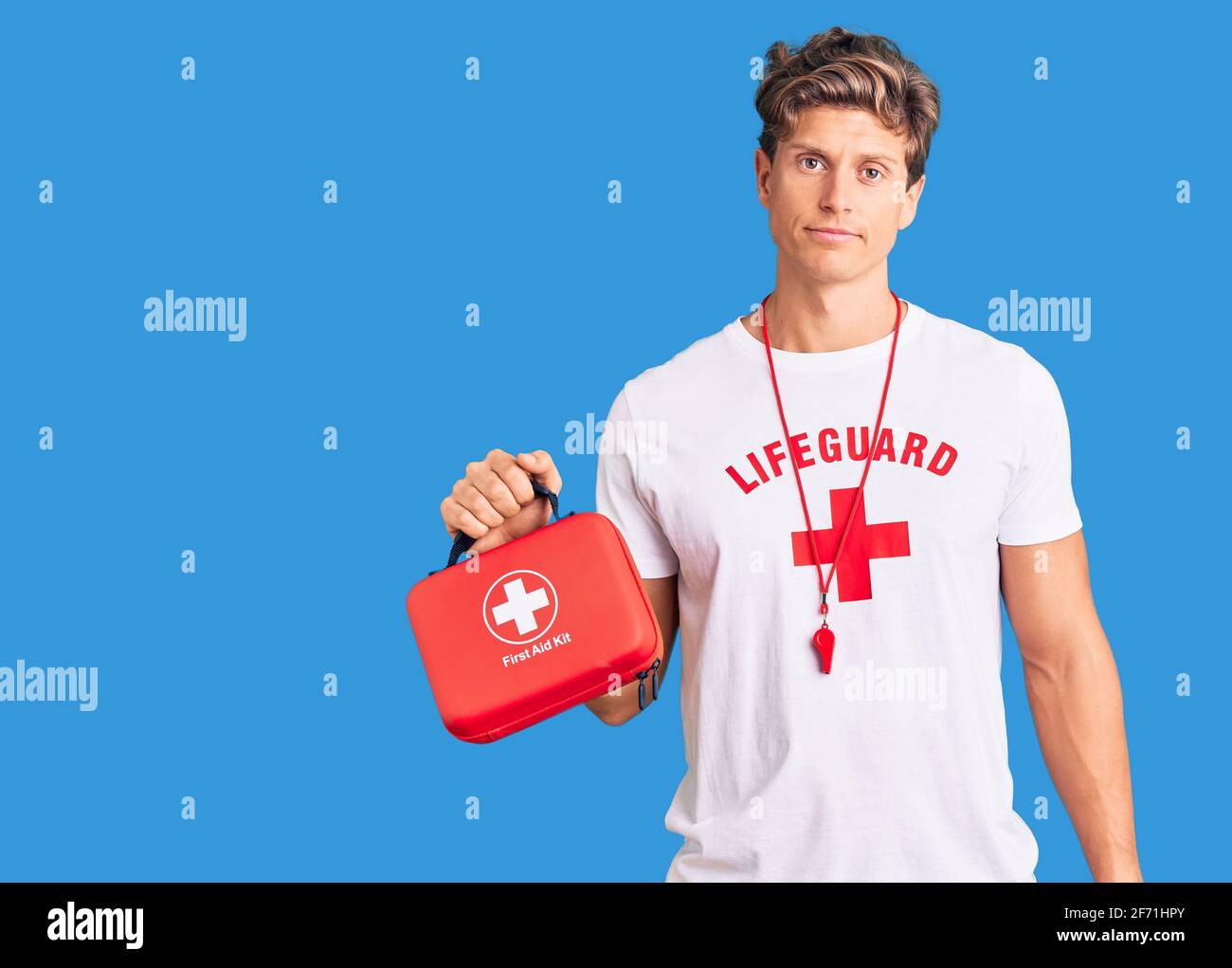 Young handsome man wearing lifeguard t shirt holding first aid kit ...