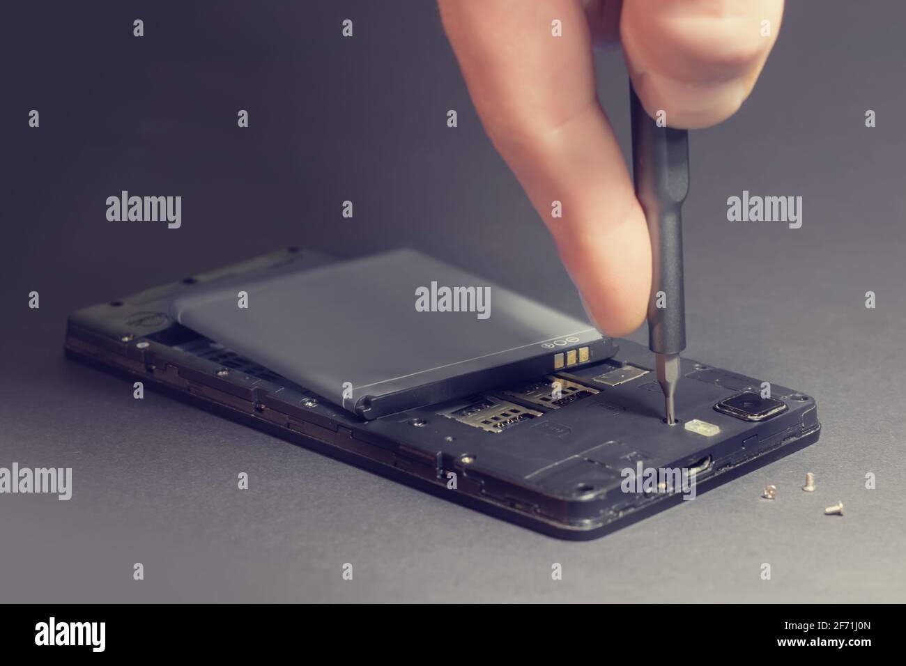 Human Hand Repairing Cellphone With Screwdriver On Desk Stock Photo - Alamy