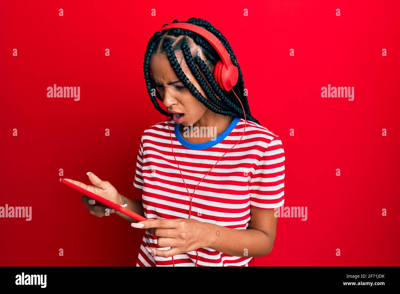 Beautiful hispanic woman using touchpad device listening to music ...