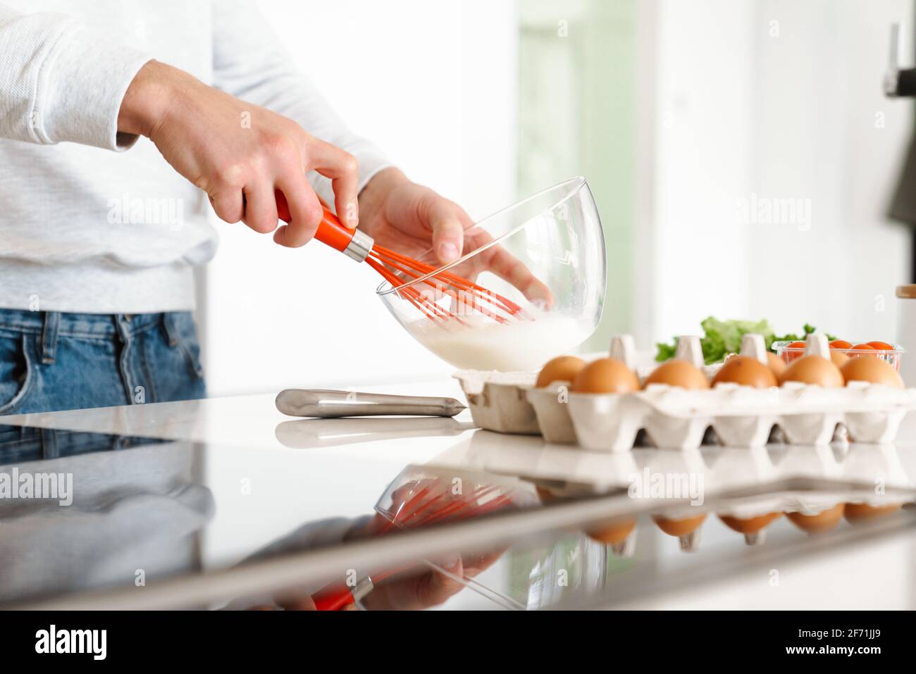 Focused handsome young man cooking scrambled eggs at home kitchen Stock ...