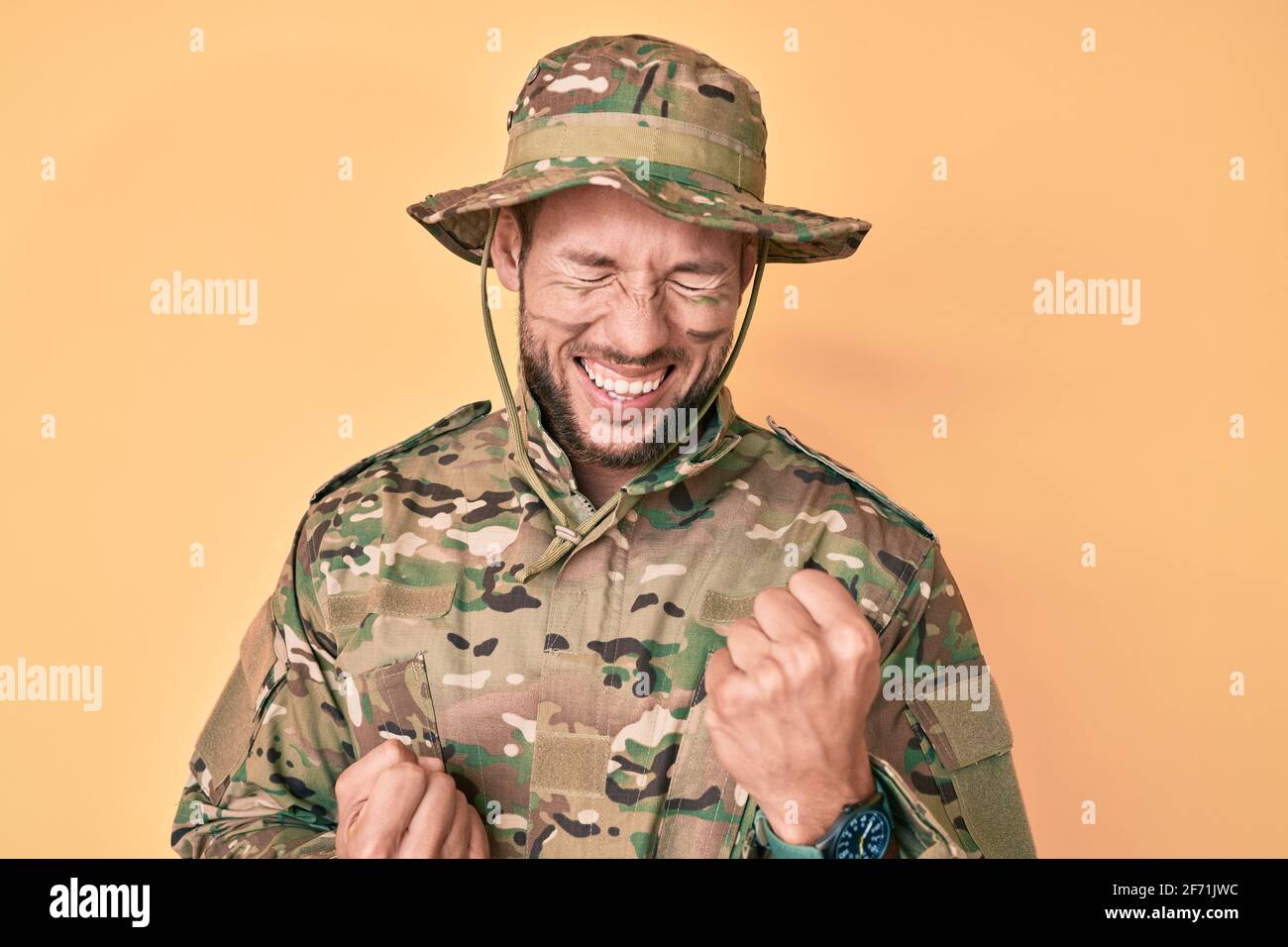 Young caucasian man wearing camouflage army uniform celebrating ...