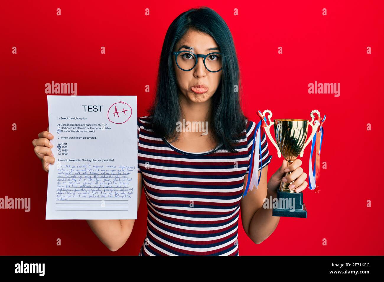 Beautiful asian young woman showing a passed exam holding trophy ...