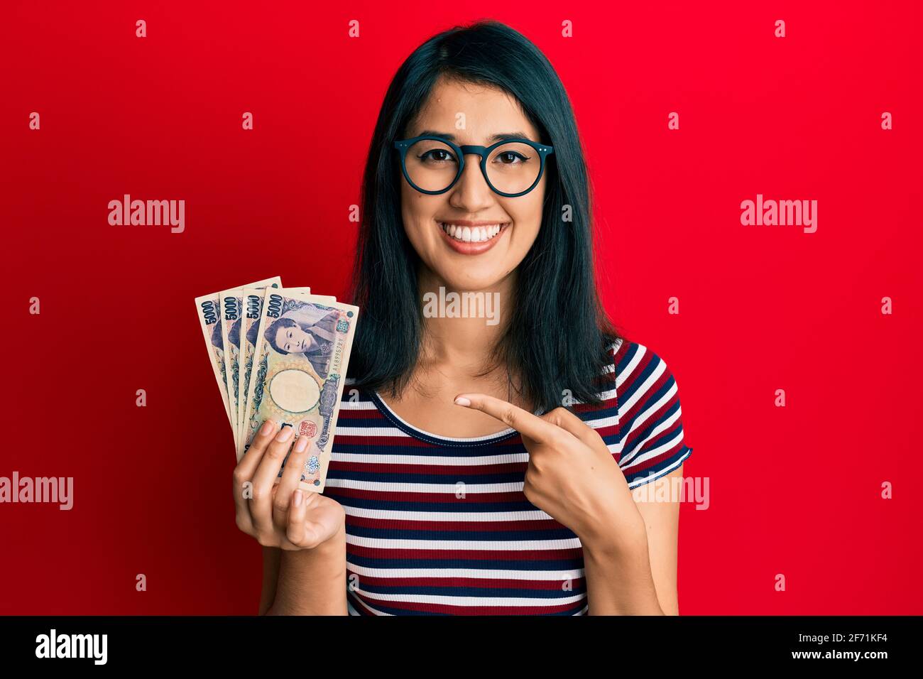 Beautiful asian young woman holding 5000 japanese yen banknotes smiling ...