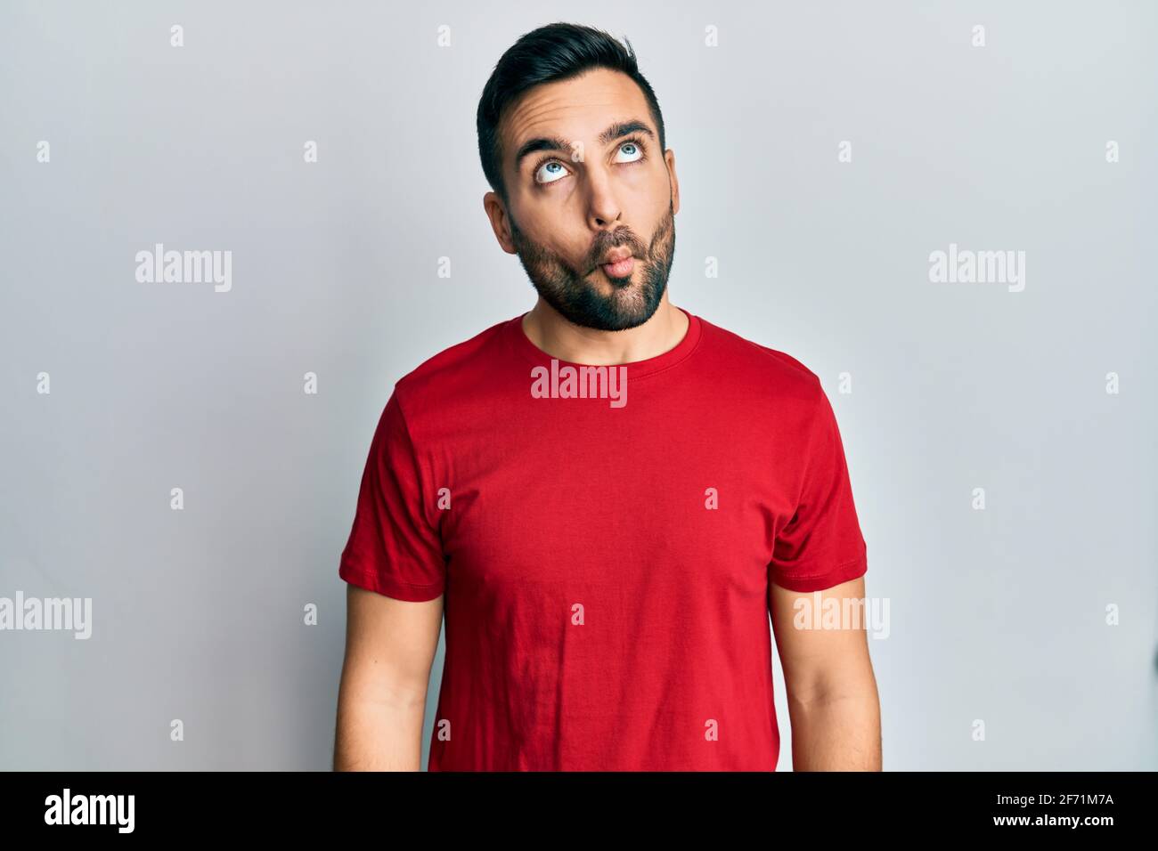 Young hispanic man wearing casual clothes making fish face with lips ...