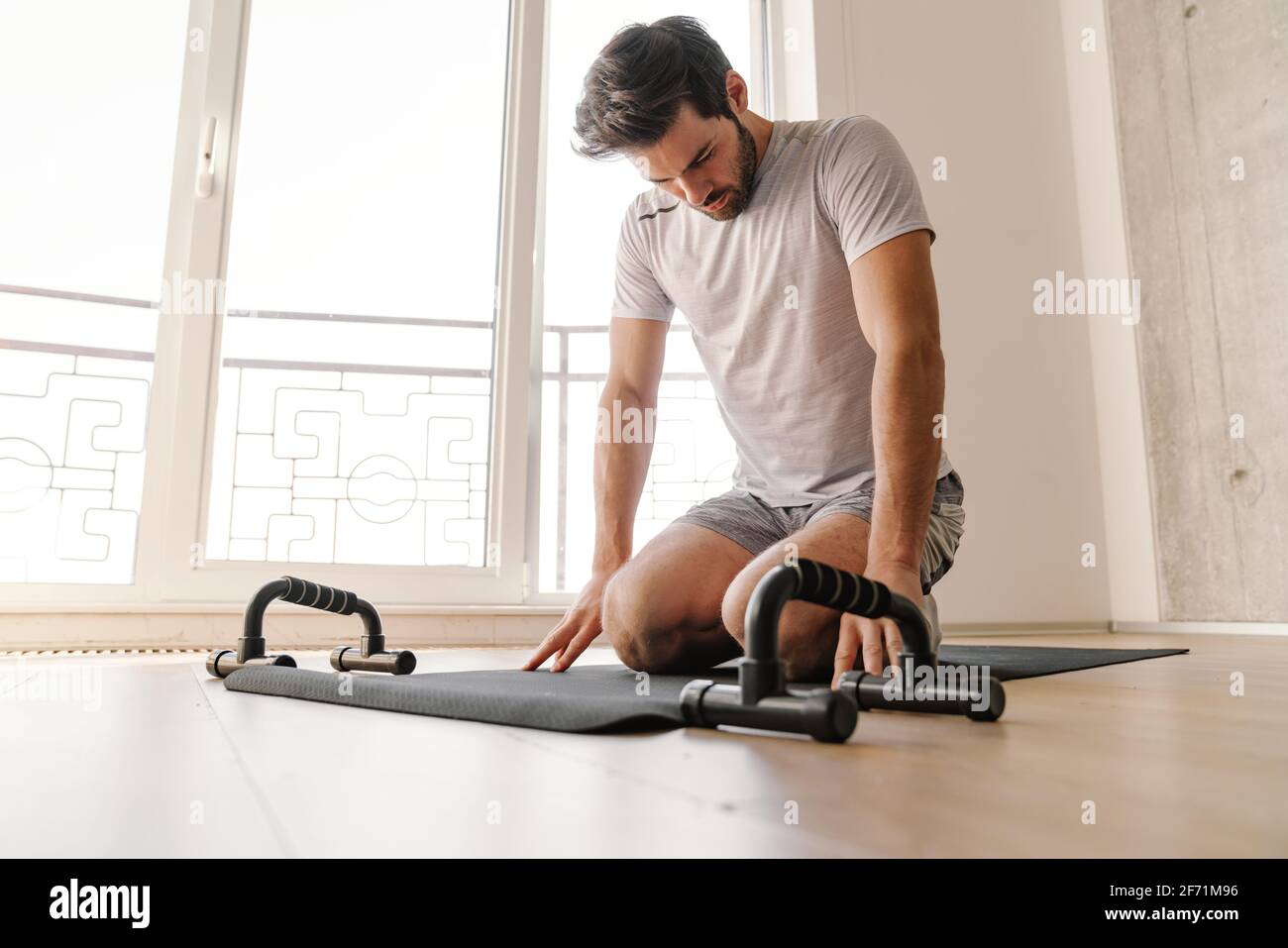 Focused athletic man doing exercise with push-up stops while working out at home Stock Photo - Alamy