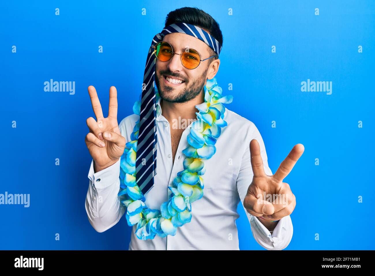 Young hispanic businessman wearing party funny style with tie on head ...