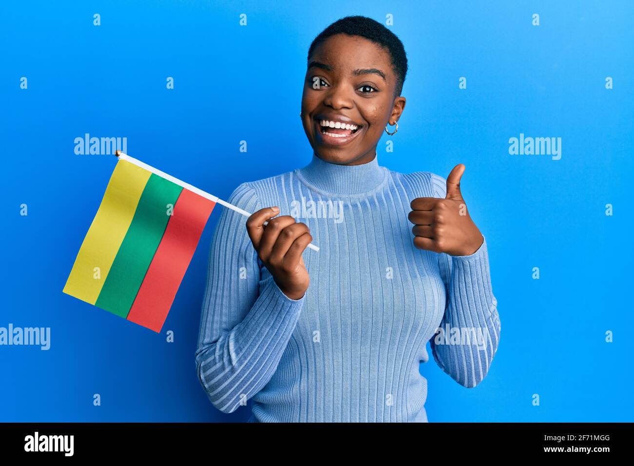 Young african american woman holding lithuania flag smiling happy and ...