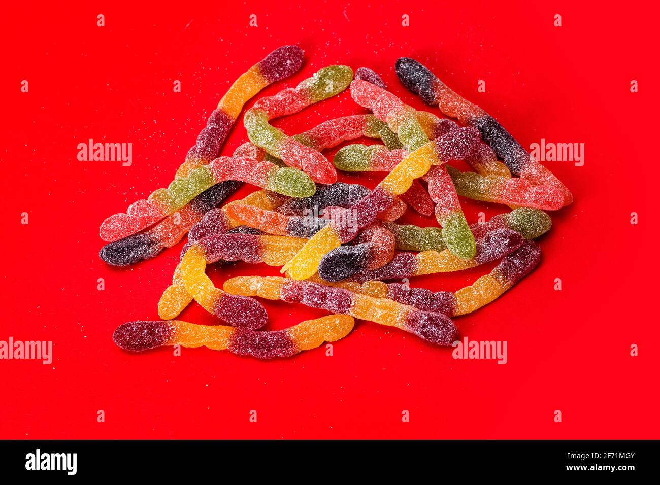 jelly worms sweets on red background Stock Photo - Alamy