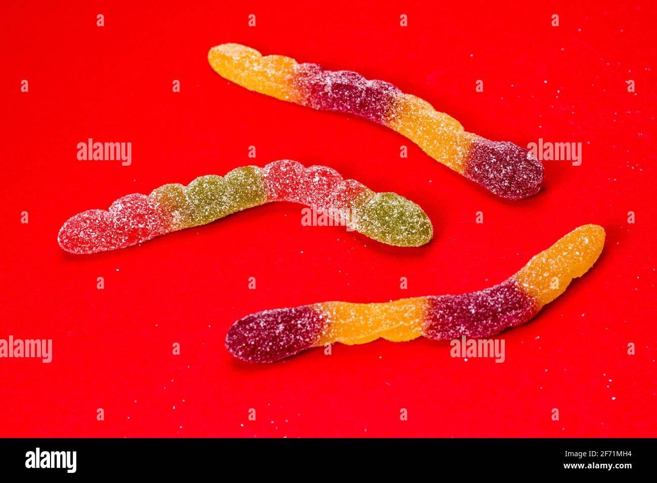 jelly worms sweets on red background Stock Photo - Alamy
