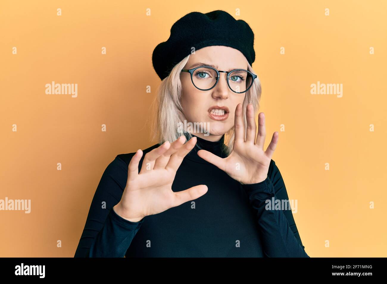 Young blonde girl wearing french look with beret disgusted expression ...