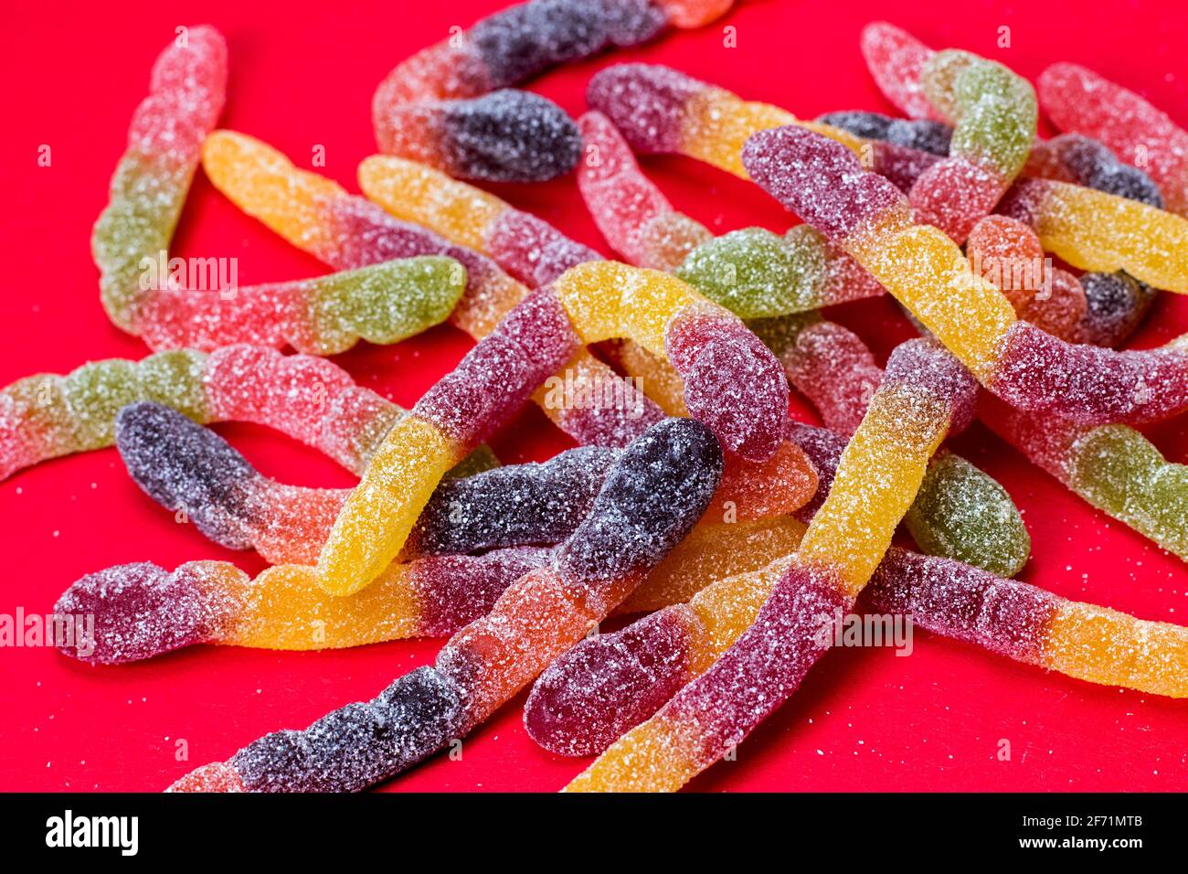jelly worms sweets on red background Stock Photo - Alamy