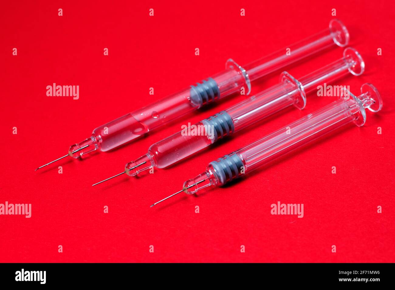 Syringes isolated on red background Stock Photo - Alamy