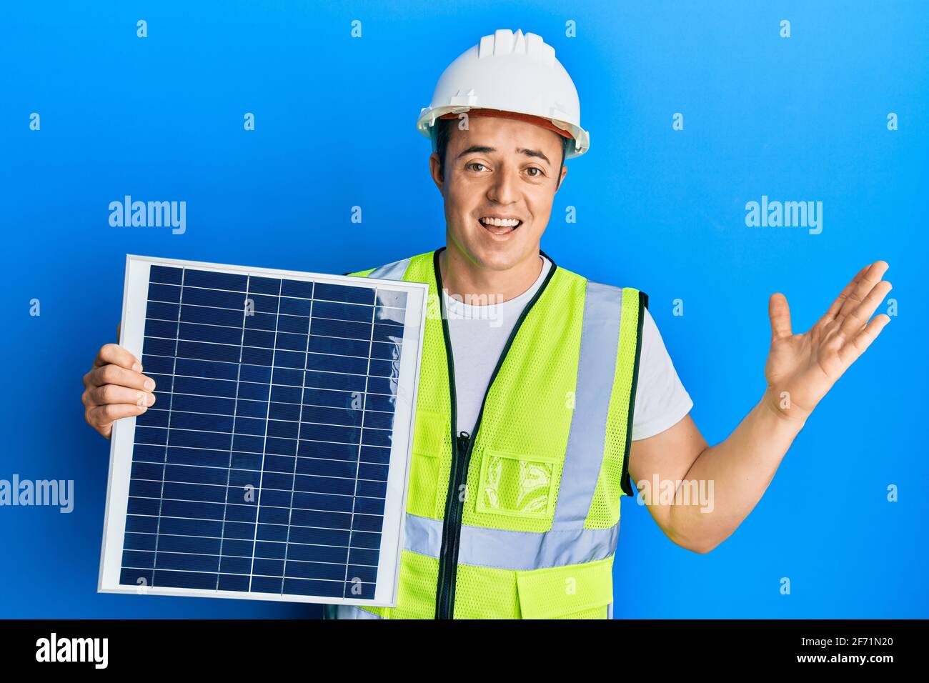 Handsome young man holding photovoltaic solar panel celebrating victory ...