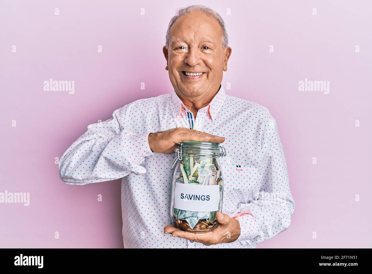 Senior caucasian man holding jar with savings smiling with a happy and ...