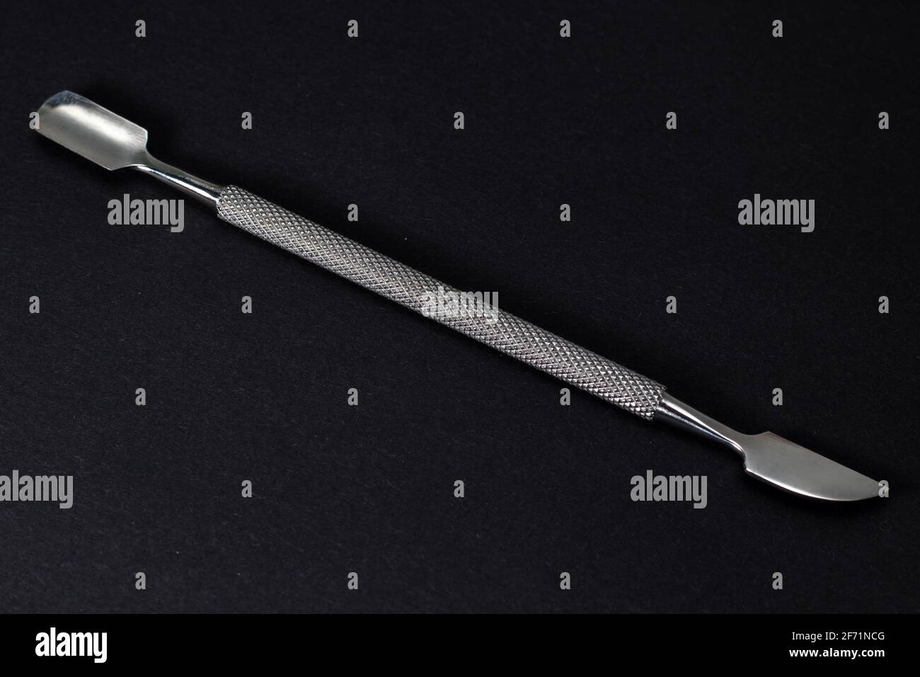 Manicure tool - scapula on black background Stock Photo - Alamy