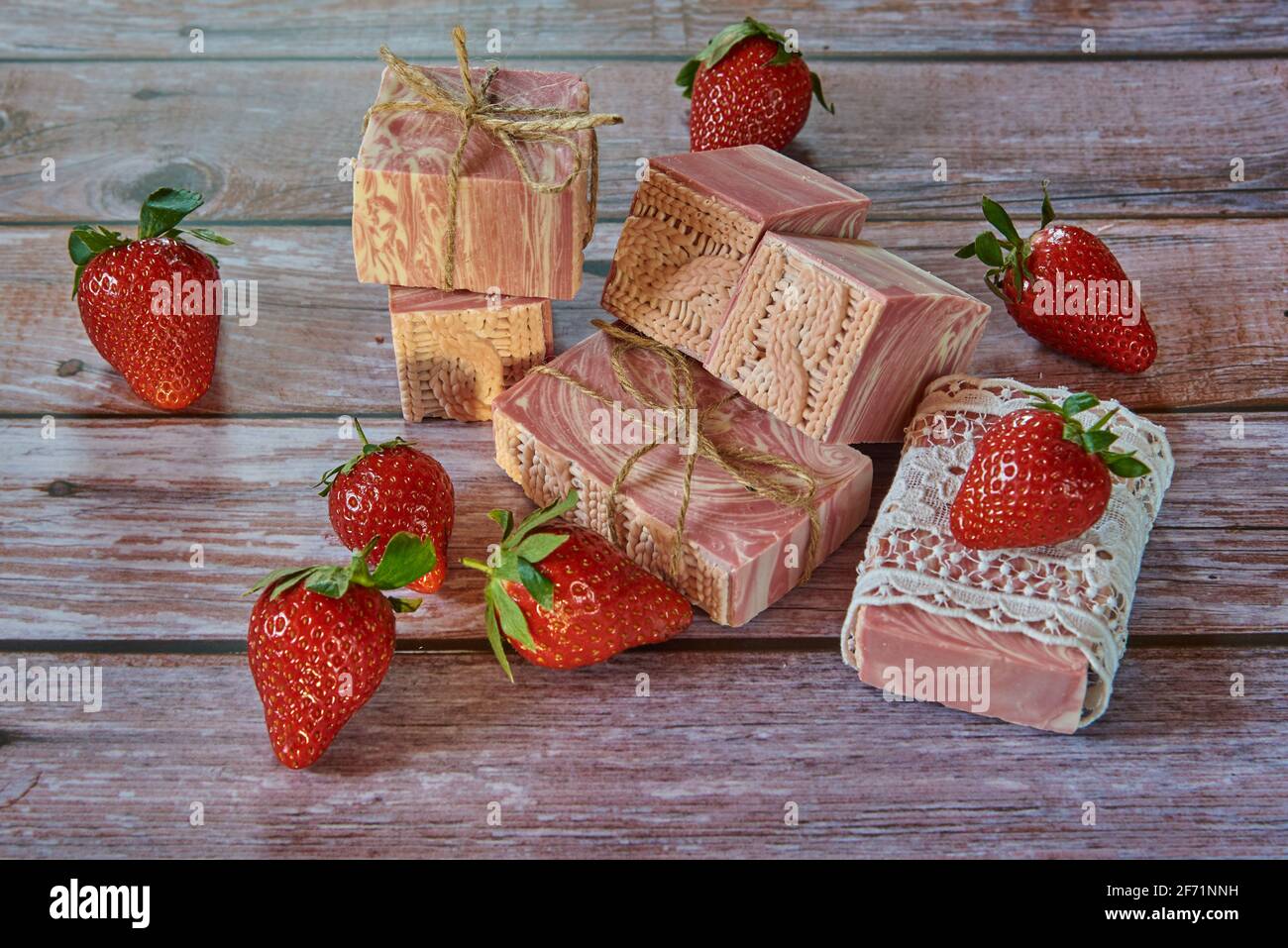 Pink textured handmade soap, lace and strawberries on a wooden ...