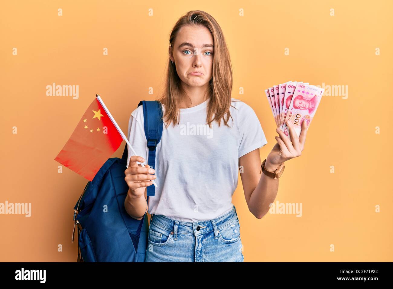 Beautiful blonde woman exchange student holding china flag and yuan ...