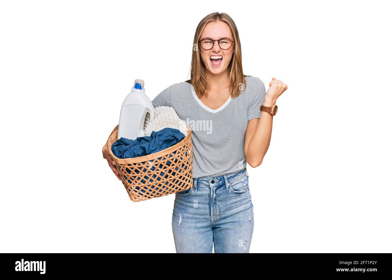 Beautiful blonde woman holding laundry basket and detergent bottle ...
