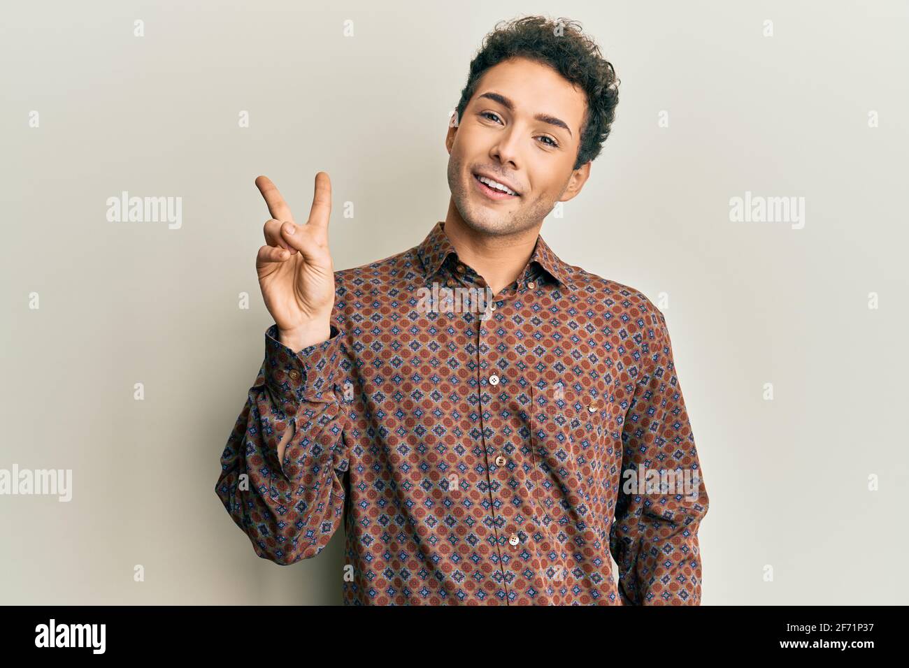 Handsome hispanic man wearing casual clothes showing and pointing up ...