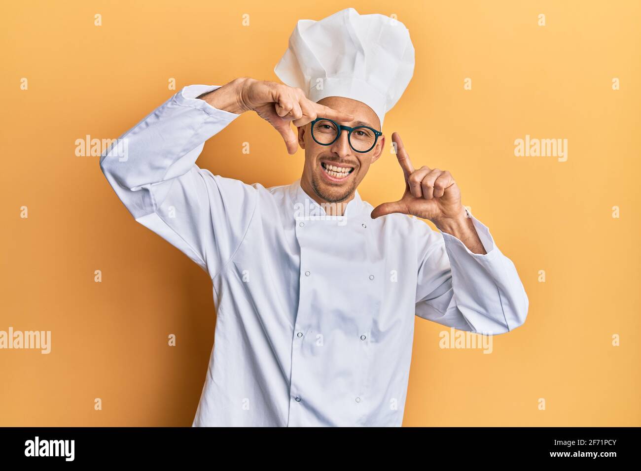 Bald man with beard wearing professional cook uniform smiling making ...