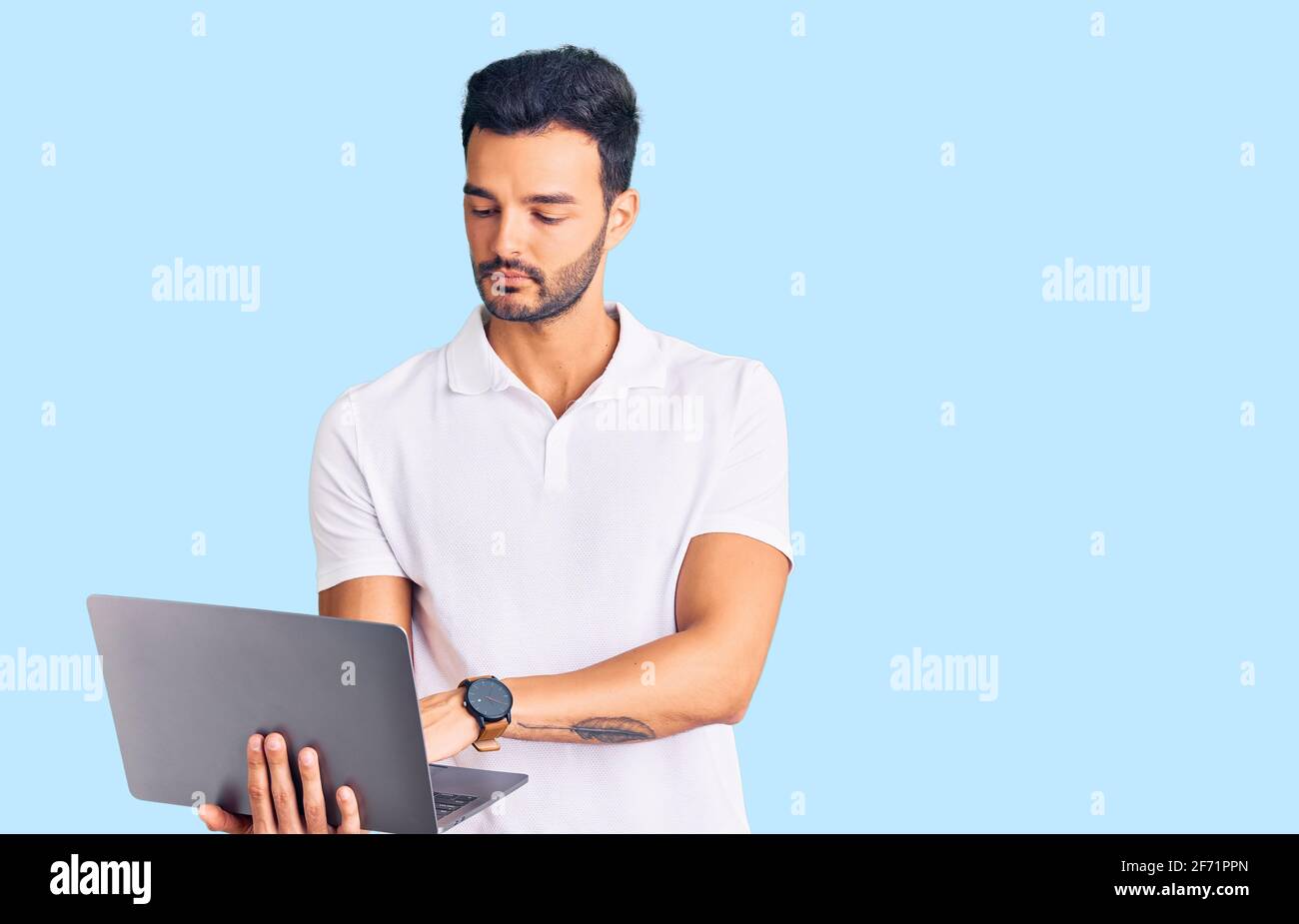 Young handsome hispanic man working using computer laptop thinking ...