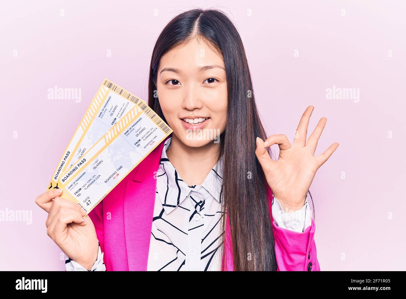 Young beautiful blonde woman holding airline boarding pass doing ok ...