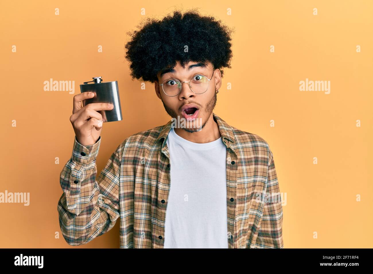 Young african american man with afro hair drinking alcohol from whiskey ...