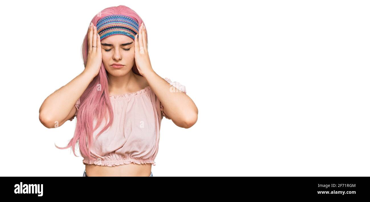 Young hispanic girl with pink hair suffering from headache desperate ...
